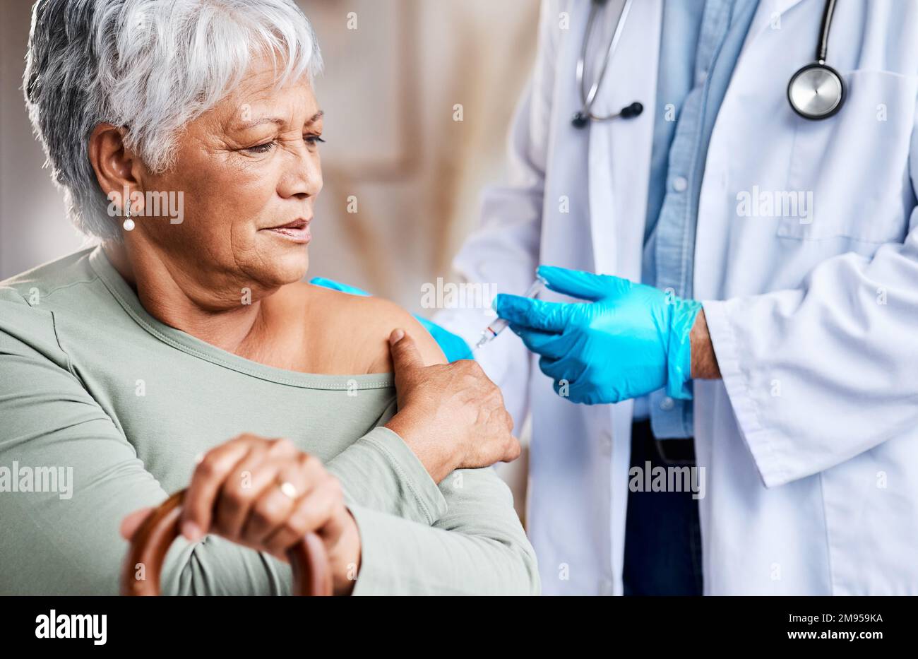 The second jab burns a bit. a doctor giving an older woman an injection ...