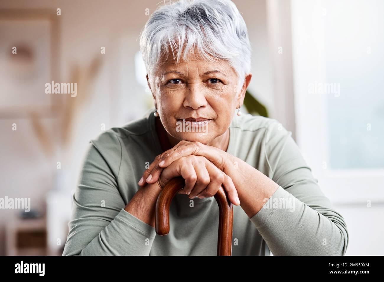 Weighed down and blue. a senior woman leaning in her walking stick at ...