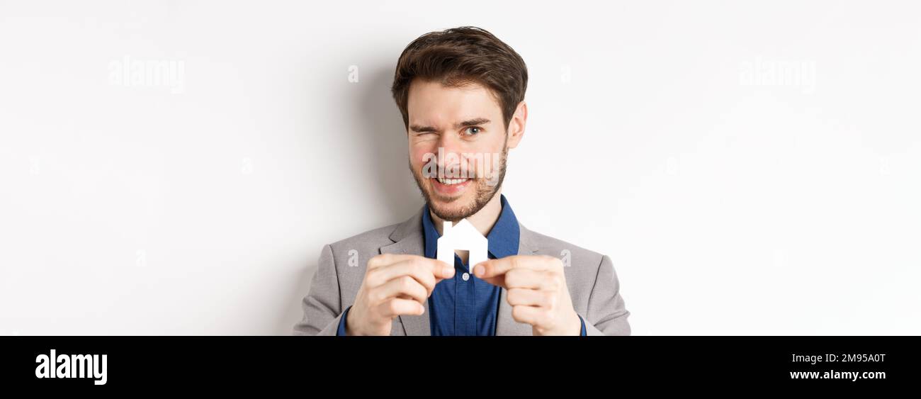 Real estate and insurance concept. Handsome man in suit winking and ...