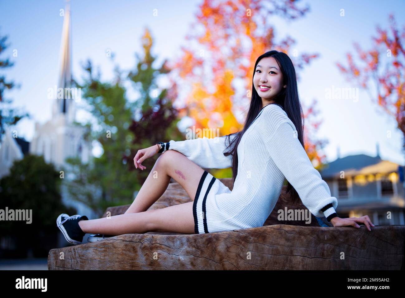 Teenage Girl Sitting on Bench in Suburban Park with Fall Colored Leaves ...