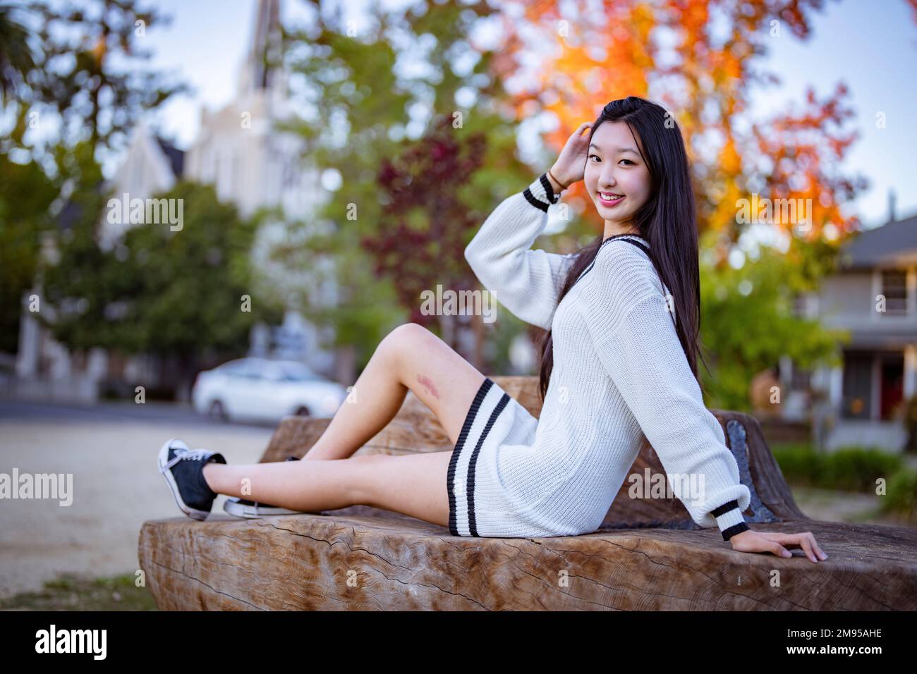 Teenage Girl Sitting on Bench in Suburban Park with Fall Colored Leaves ...