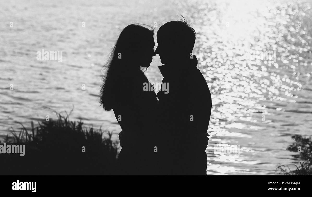 couple in love hugging by the water, the silhouette Stock Photo - Alamy