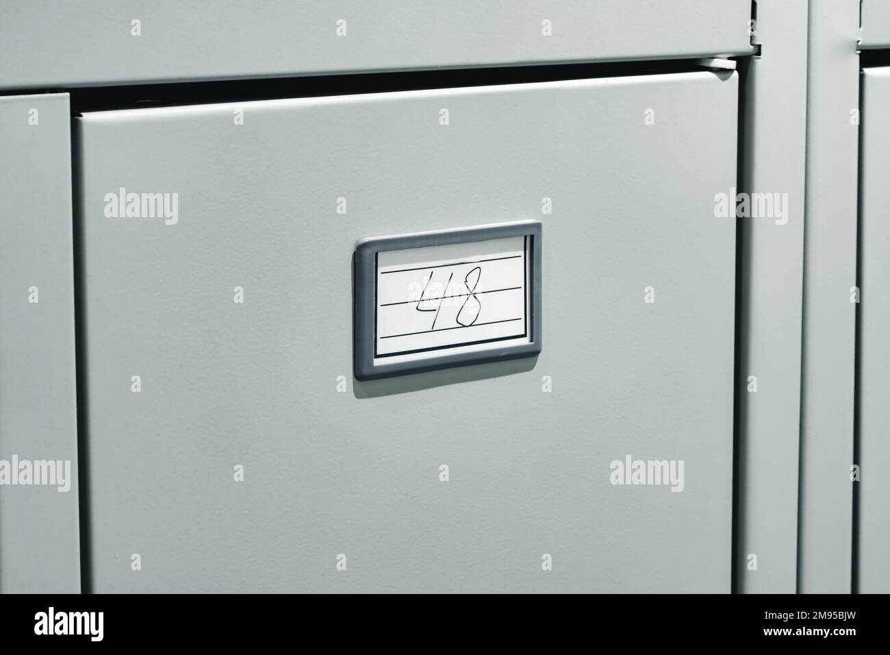 Gray file cabinet with document files in office Stock Photo - Alamy