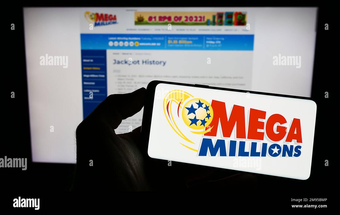 Person holding mobile phone with logo of US lottery Mega Millions on ...