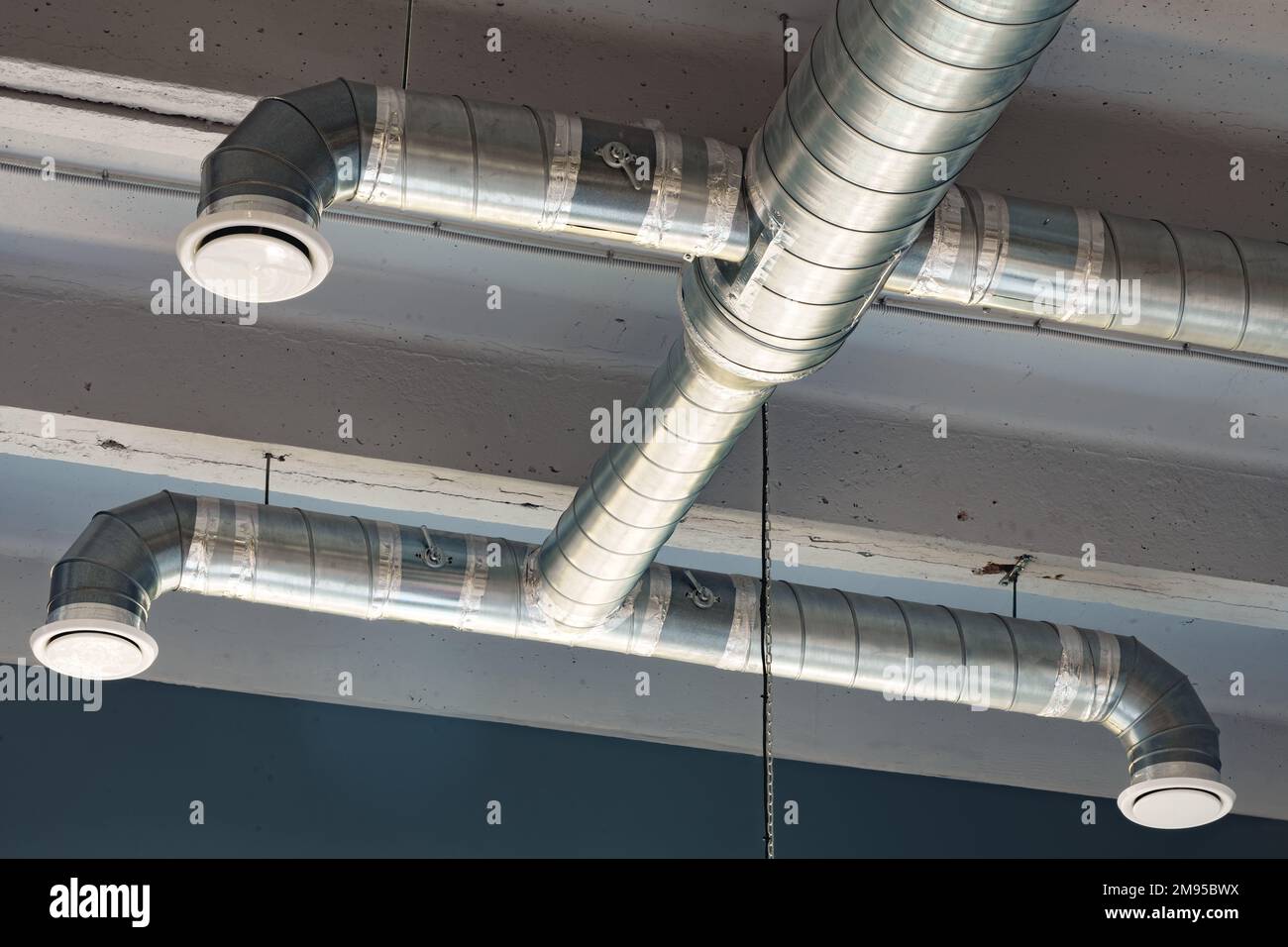 Silver ventilation pipes hanging from the ceiling inside the building ...