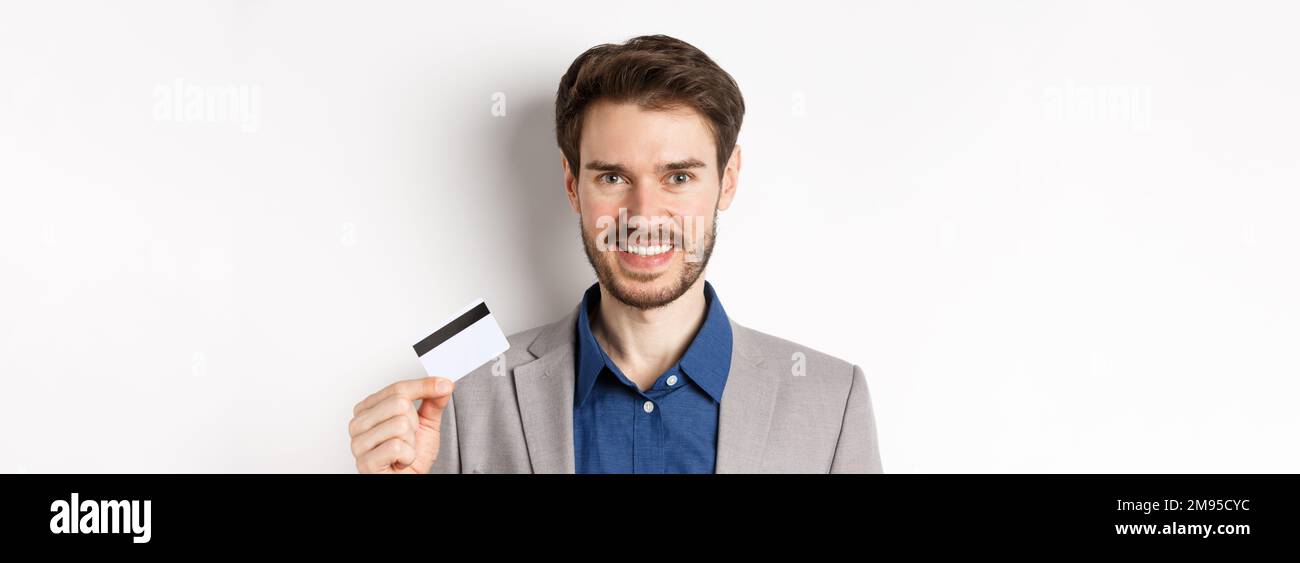 Shopping. Handsome candid business man in suit showing plastic credit ...