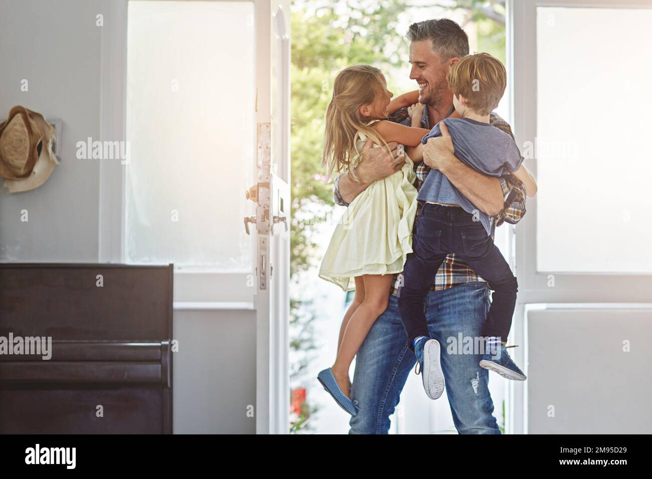 Family, father and children with hug and fun, love and hello at door ...
