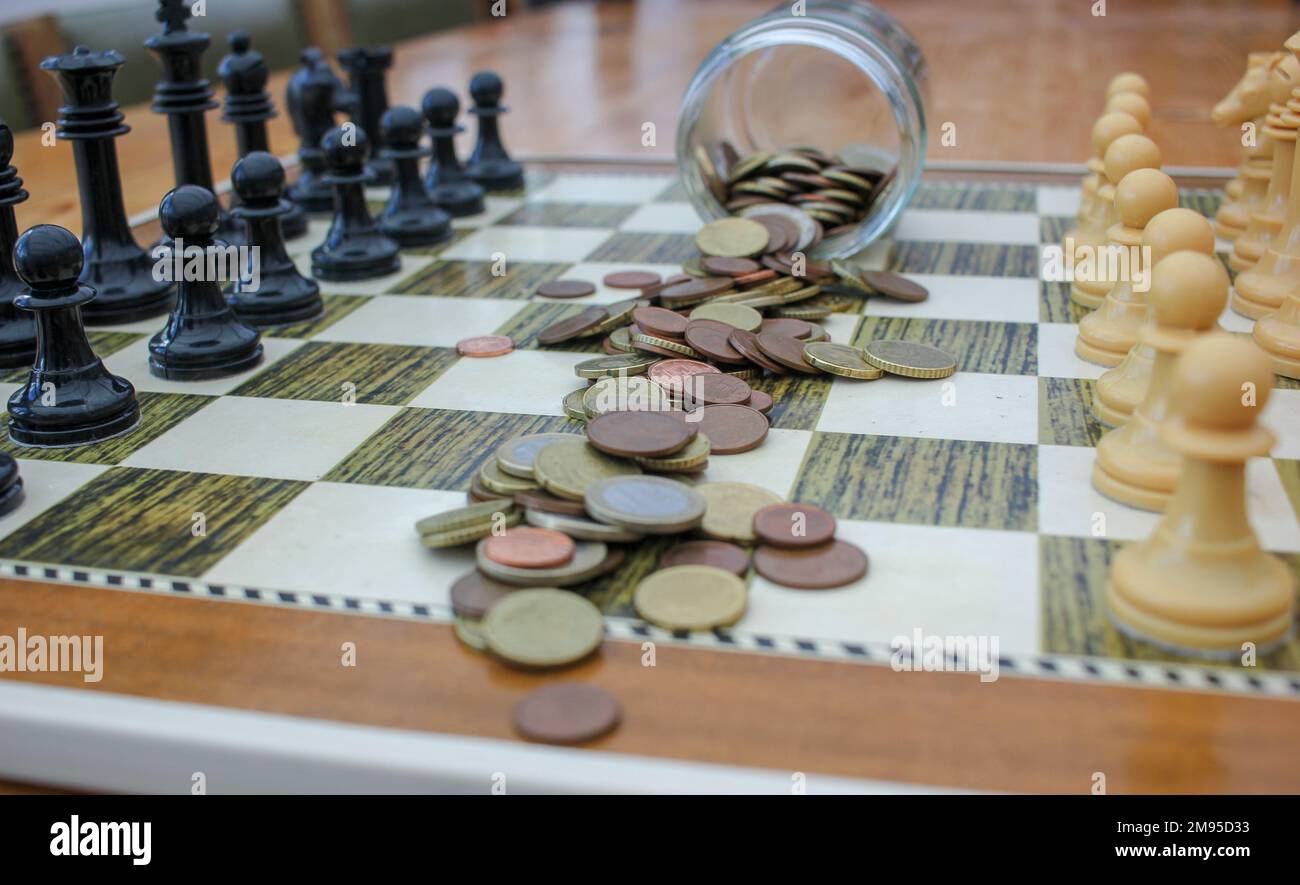 euro coins scattered on a chessboard, cocept, having to think about ...