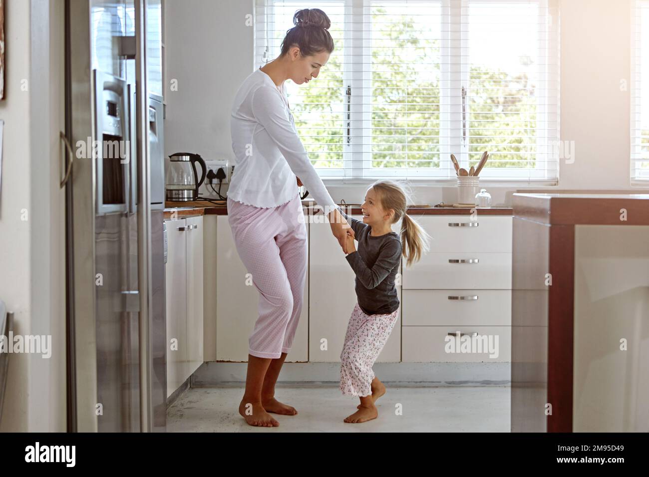 Kitchen dancing, mother and daughter in the morning at home with ...