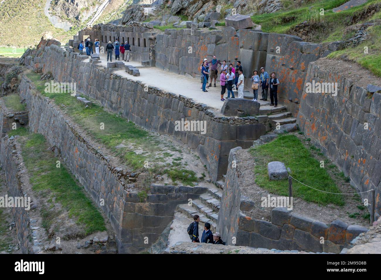 Tourists stand on one of the interlocking stone wall terraces at ...