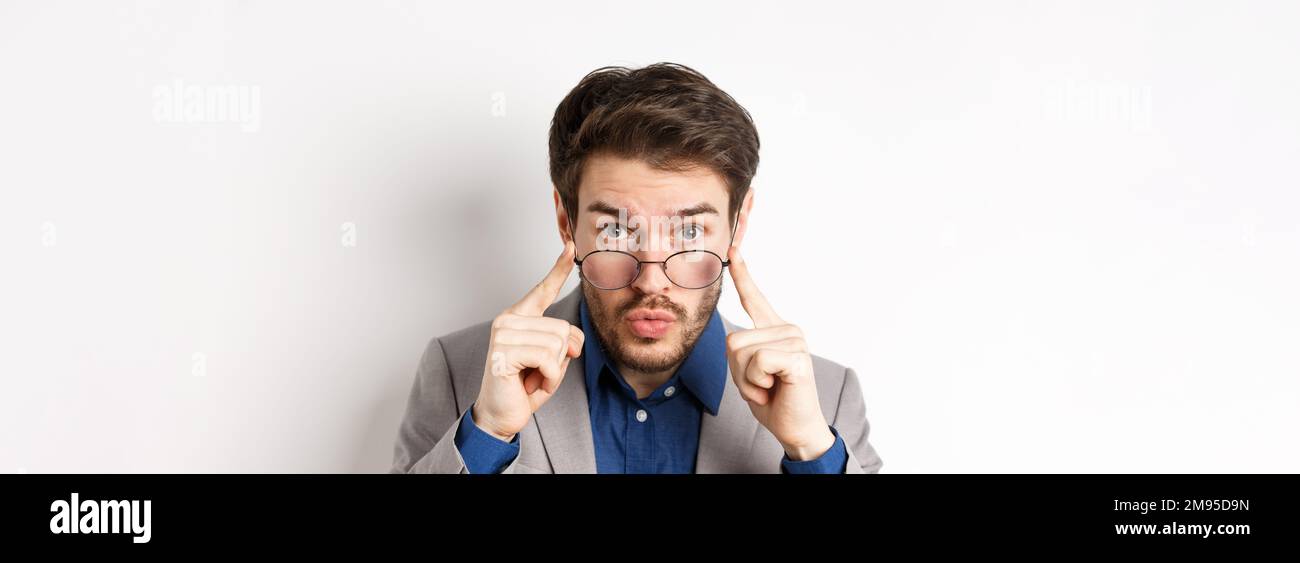 Surprised businessman takes-off glasses and look excited at camera ...