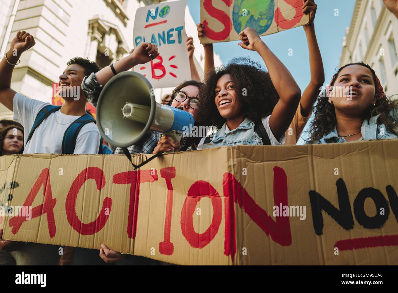 Multiethnic climate activists protesting with banners and a megaphone ...
