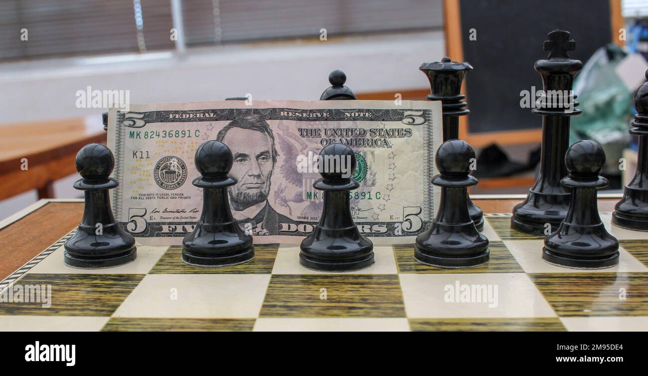 dollar bill among black chess pieces Stock Photo - Alamy