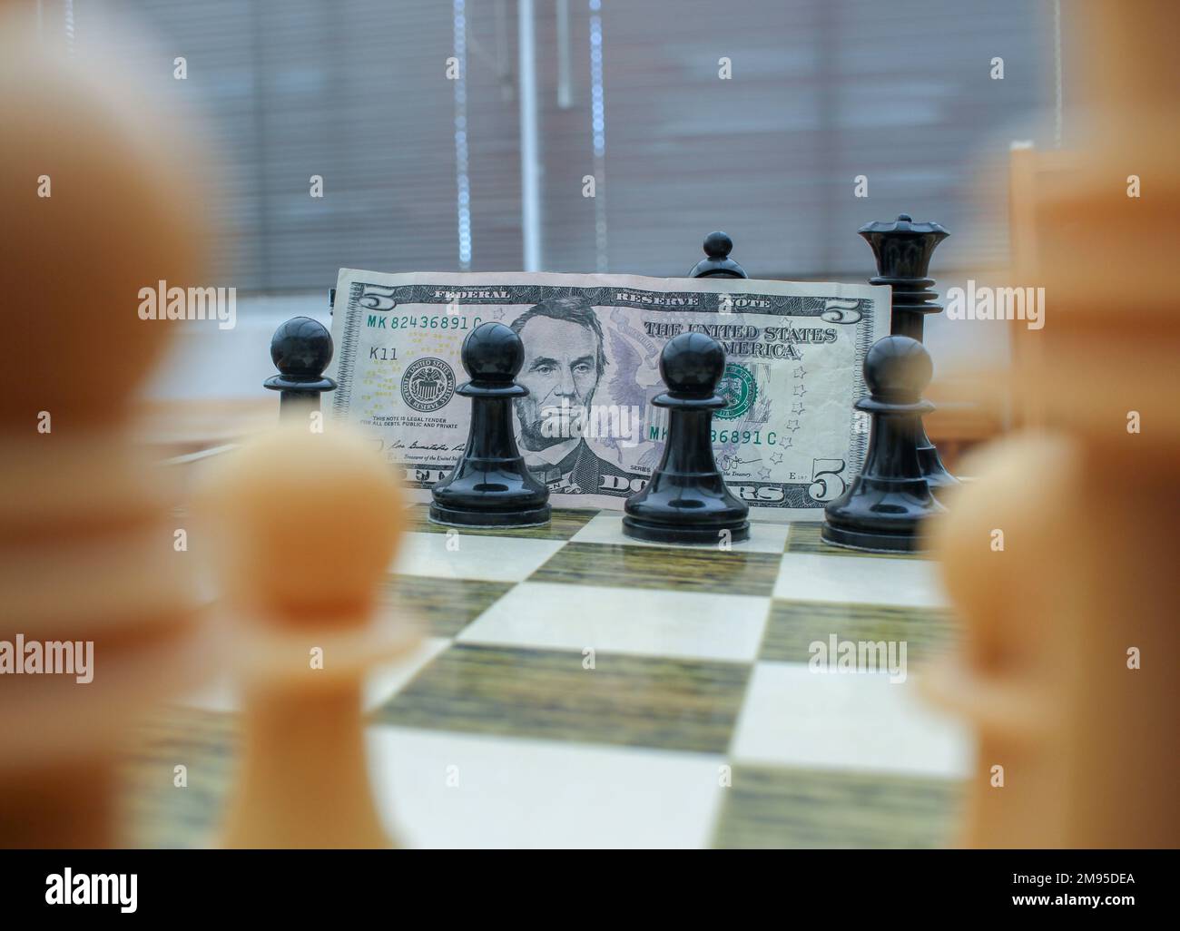 dollar bill among black chess pieces Stock Photo - Alamy