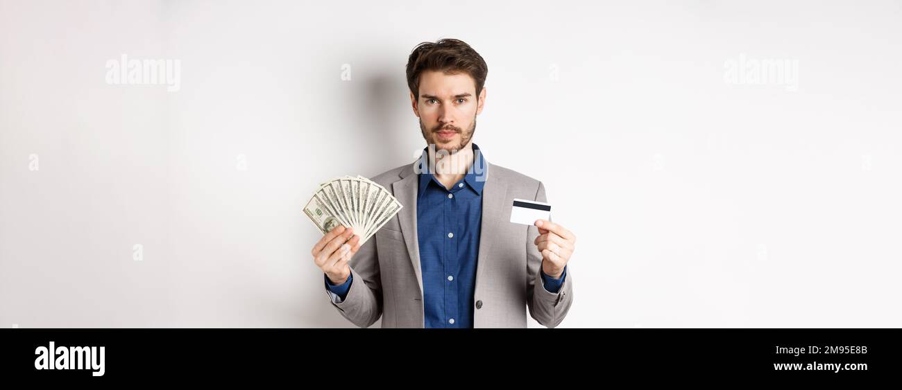 Successful businessman making money, standing in suit with dollar bills ...
