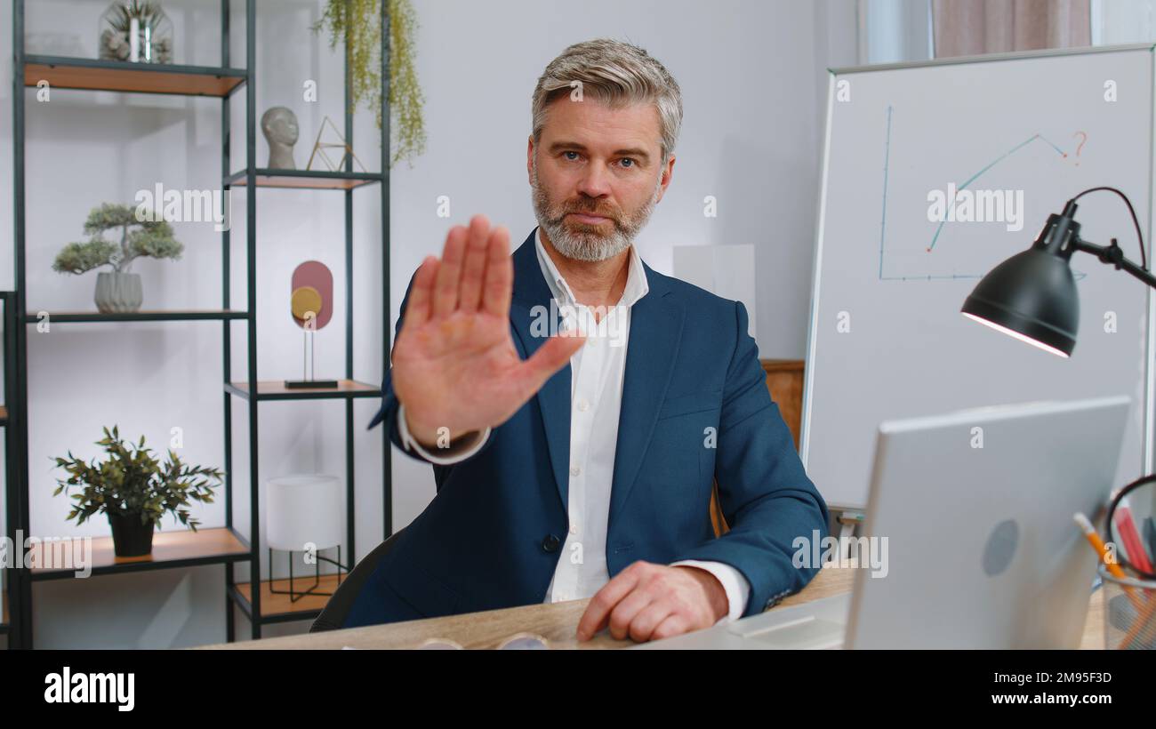 Stop. Mature businessman working on laptop, warning of finish ...