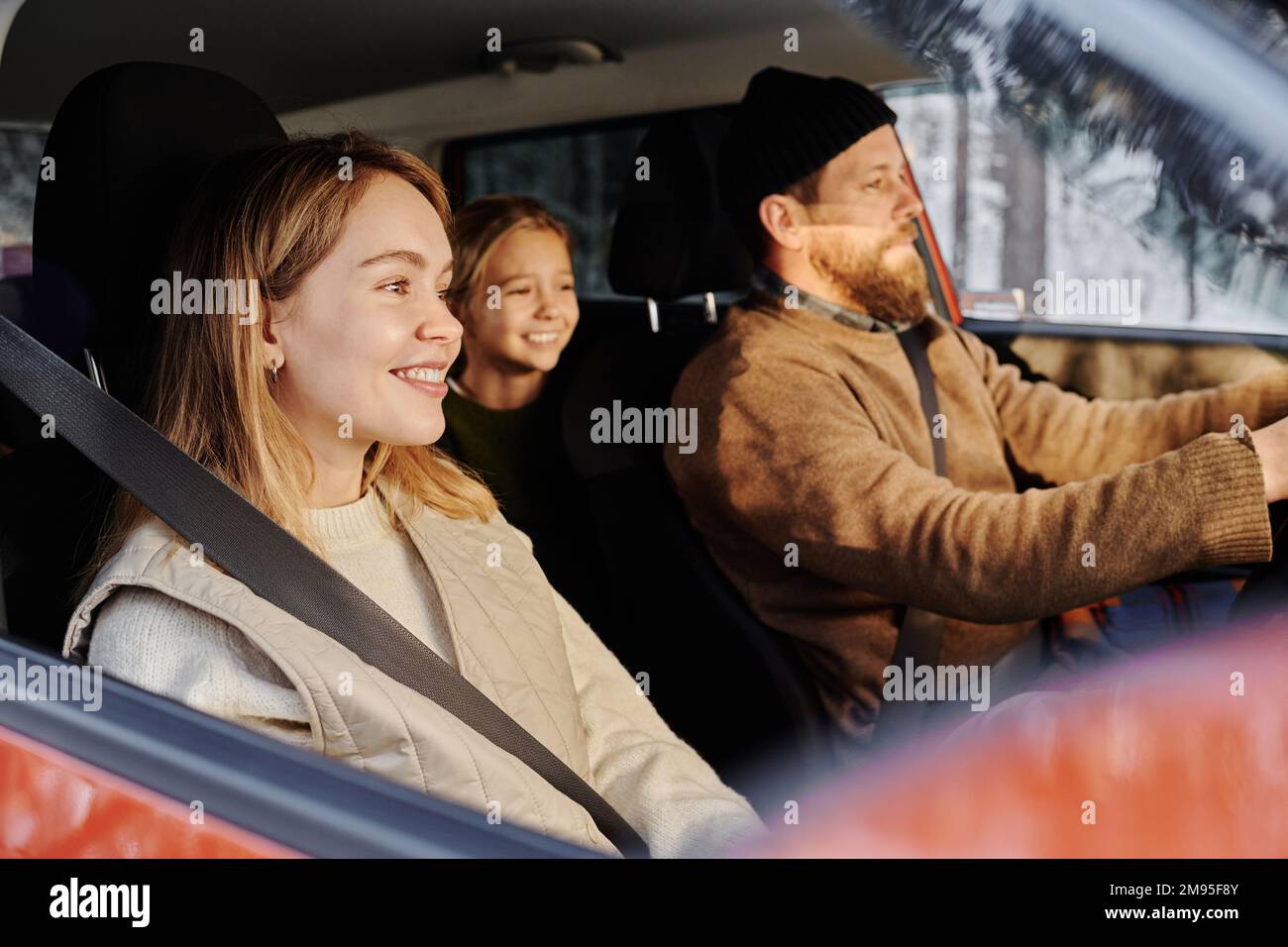 Happy family of three sitting in car and smiling, they travelling ...