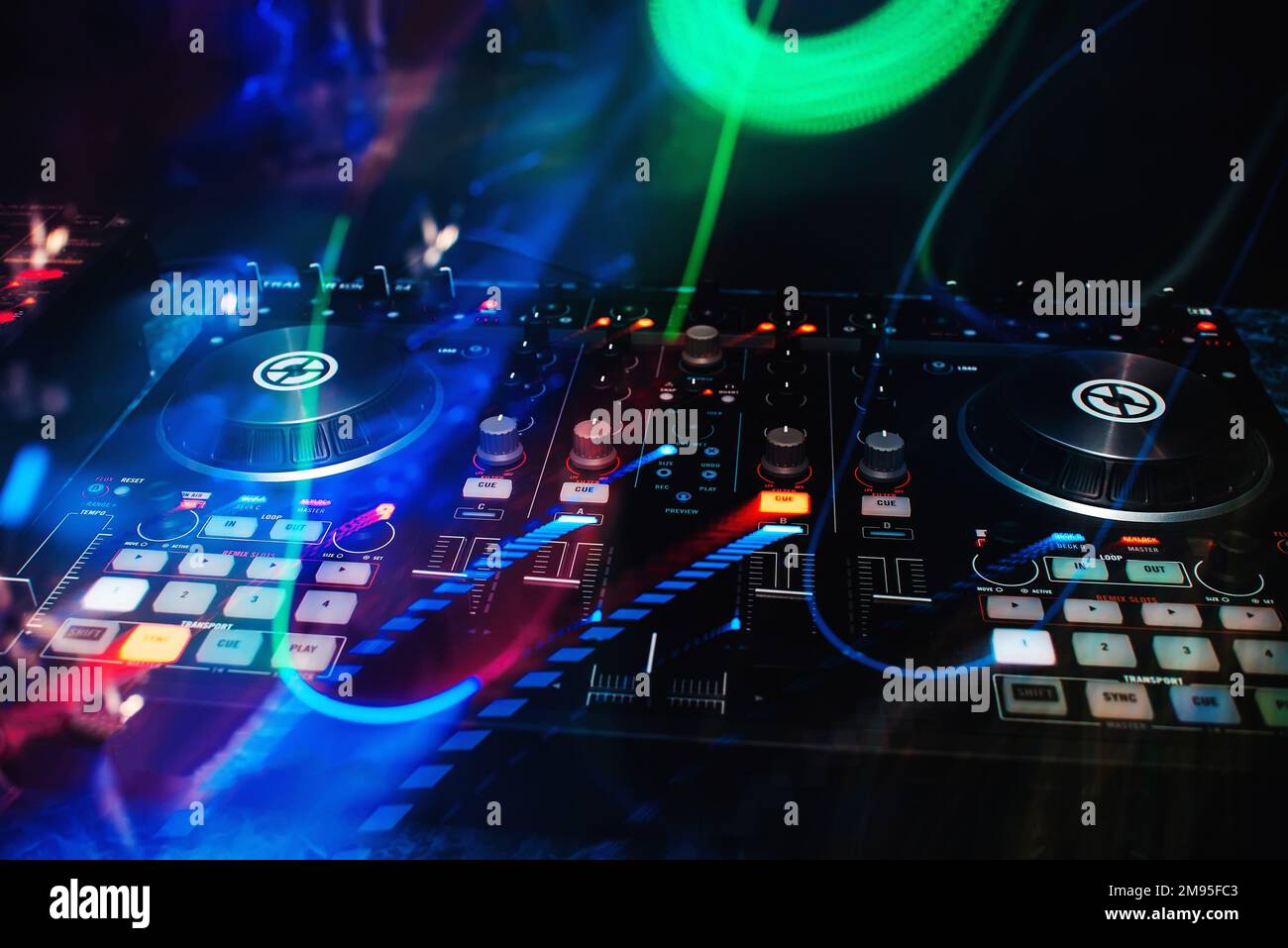music console and DJ mixer in night club with colorful effects on a ...