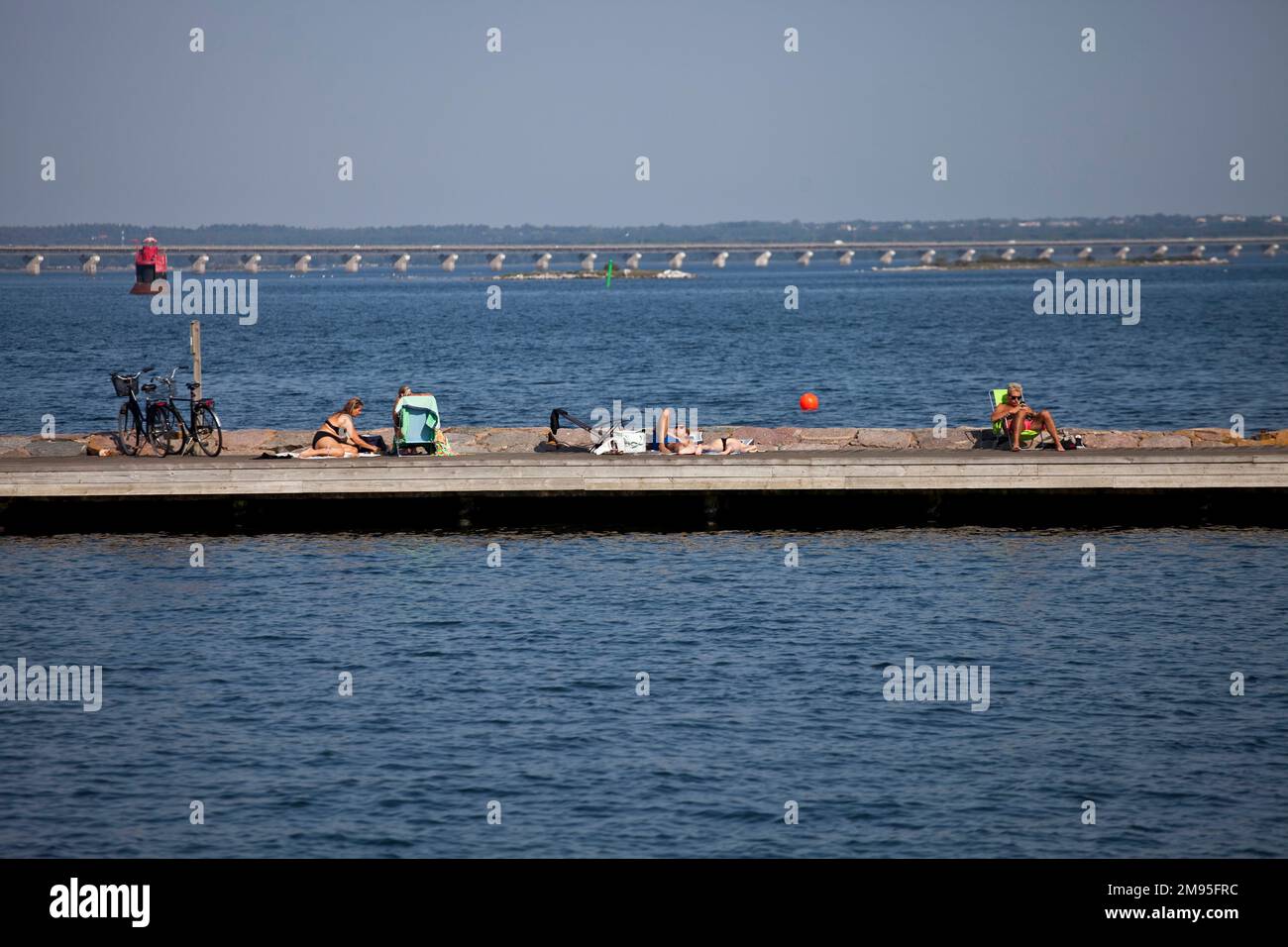 Sweden, Kalmar: people enjoying the sun with the Olandsbron Bridge in ...