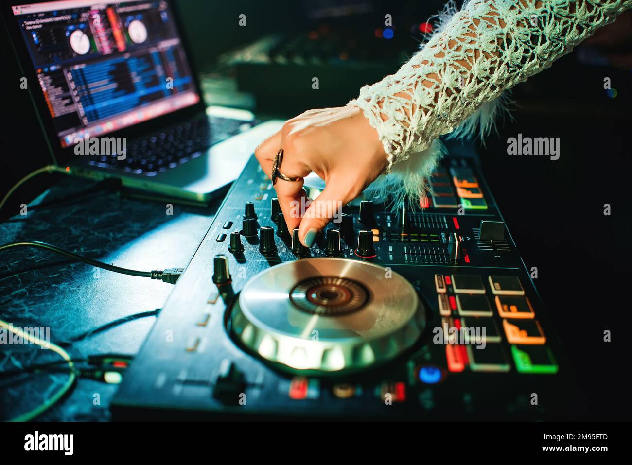 hand girl DJ with make-up and ring mixing music on professional Board ...