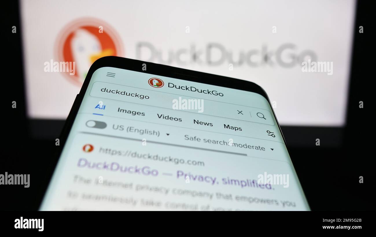 Mobile phone with website of Internet search engine DuckDuckGo (DDG) on screen in front of ...