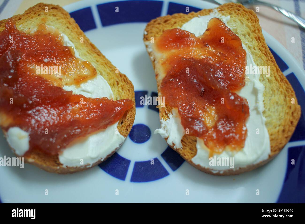 two slices of toasted bread with cheese and quince Stock Photo - Alamy