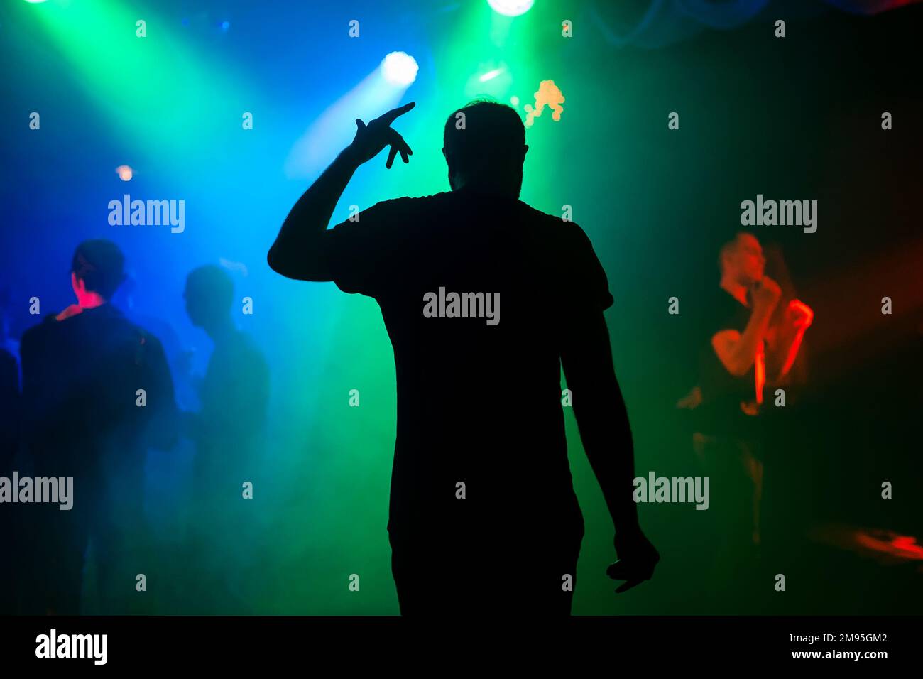 silhouette of the presenter on the night club stage at the concert back ...