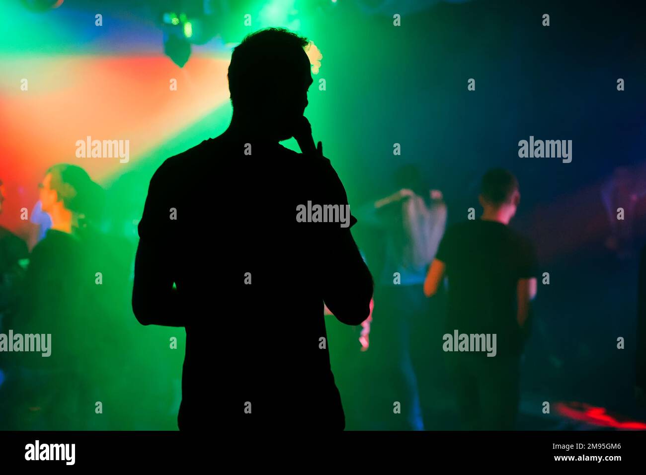 silhouette of the presenter with a microphone on the stage of a ...