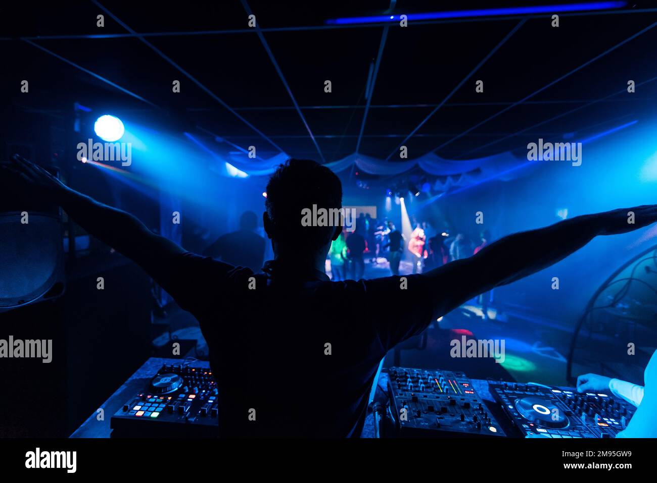 DJ squared his hands on the mixer and remote control the music in the ...