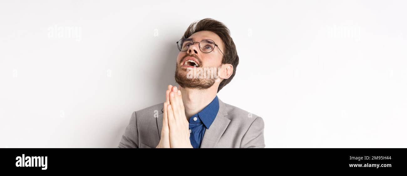 Close-up of handsome bearded man in glasses and suit looking up and ...