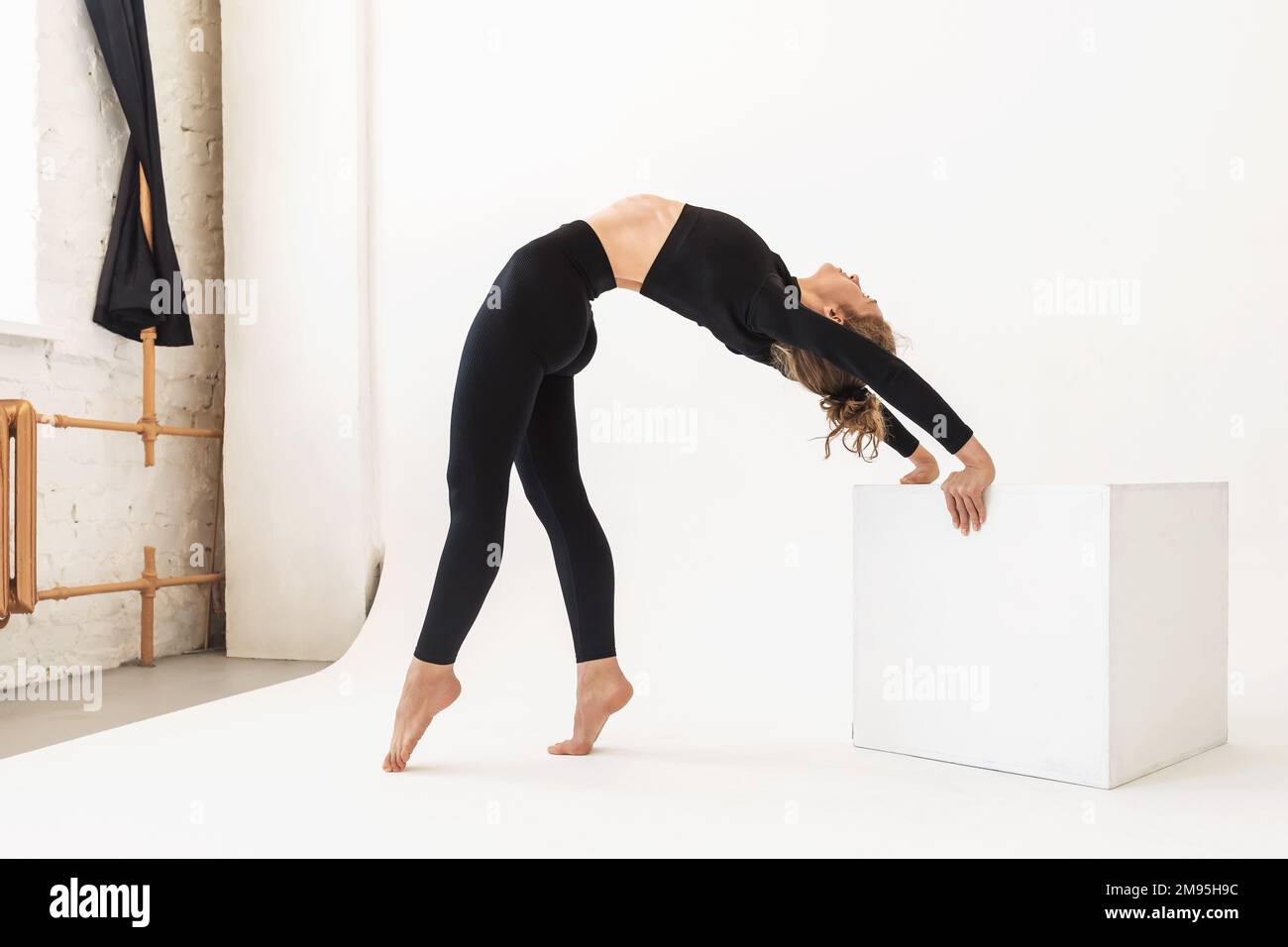 Young Woman Leading A Healthy Lifestyle And Practicing Yoga Performs
