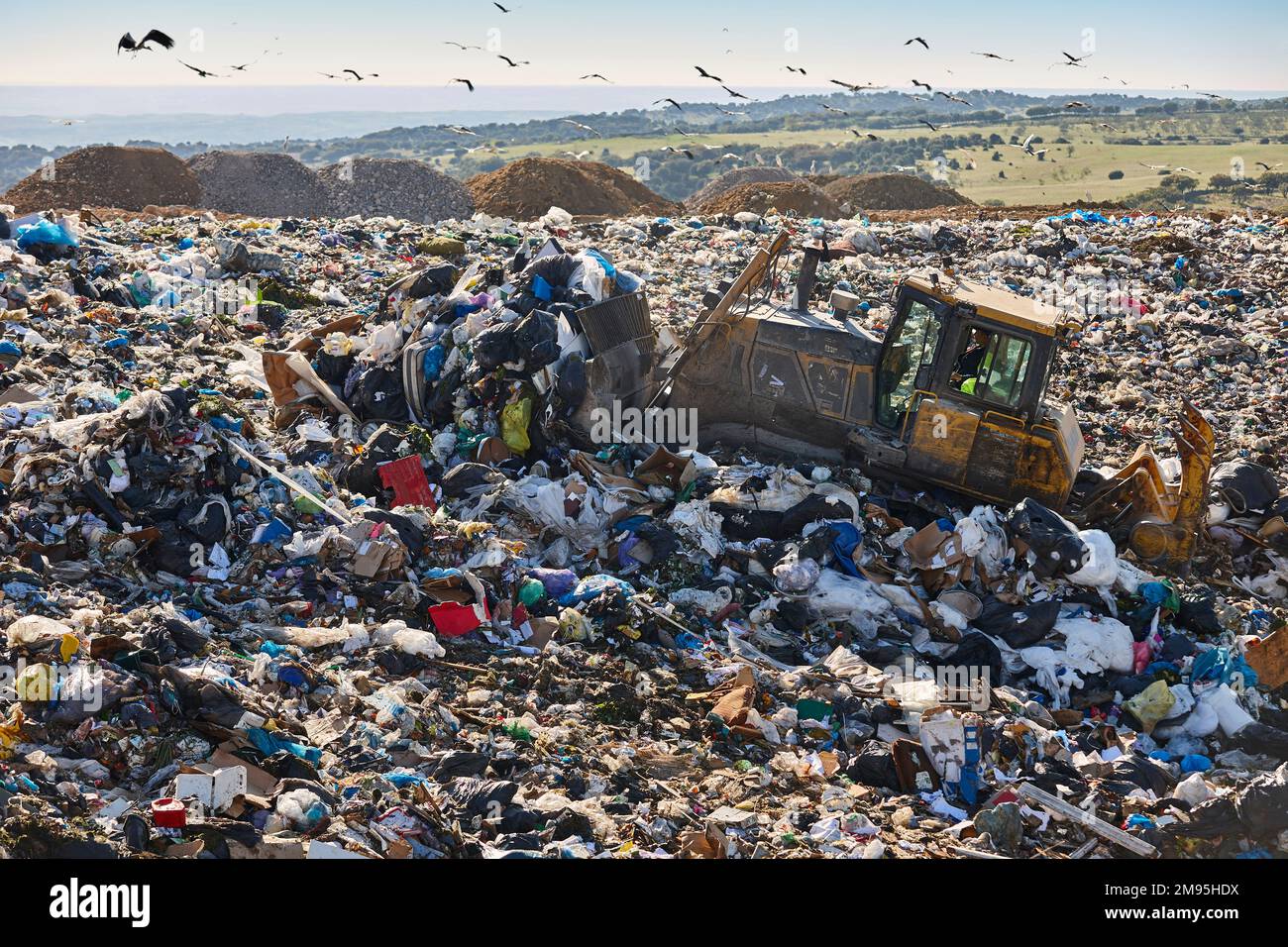 Heavy machinery shredding garbage in an open air landfill. Waste Stock ...