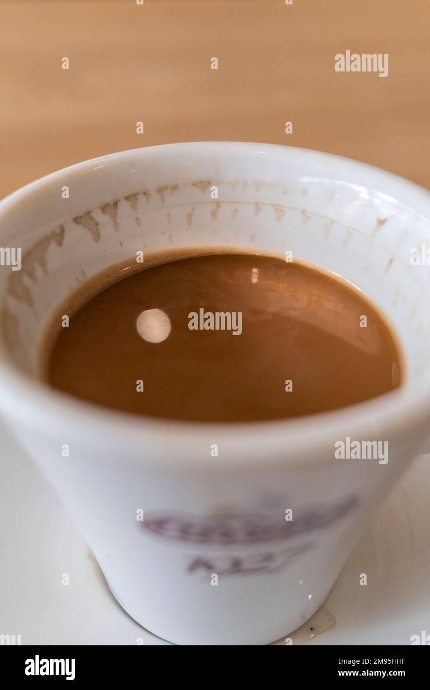 A close up closeup view of a partially consumed coffee on a table in a ...
