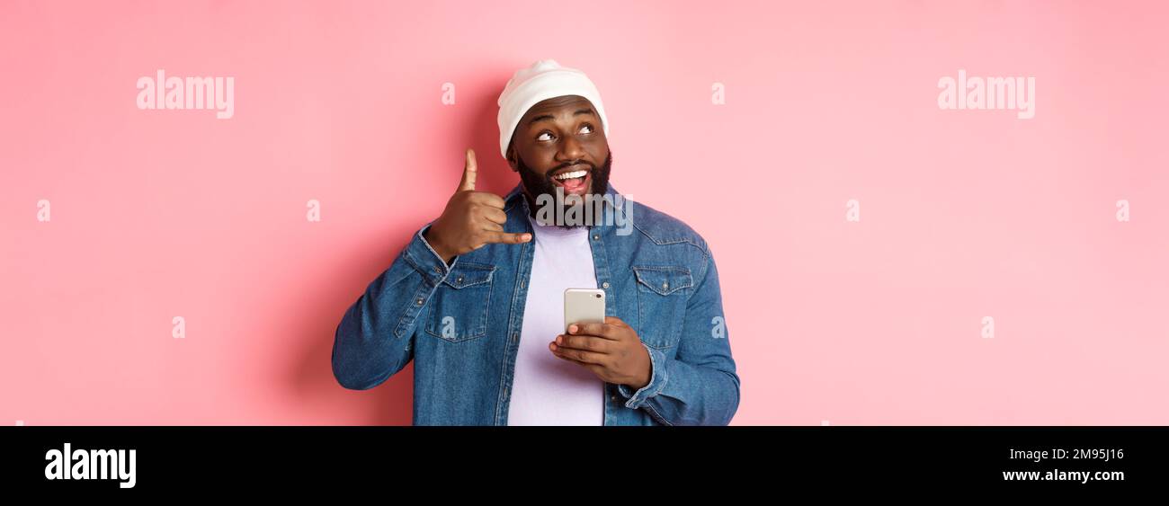 Happy Black man showing call me sign, making phone gesture and smiling ...