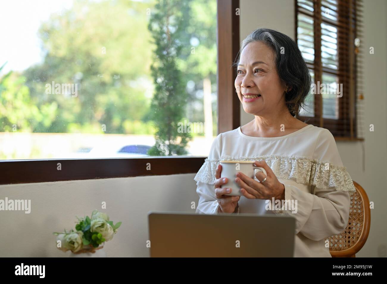Old lady looking through window hi-res stock photography and images - Alamy