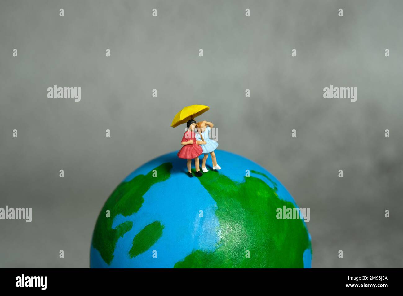 Miniature people toy figure photography. Two girls kid standing above ...