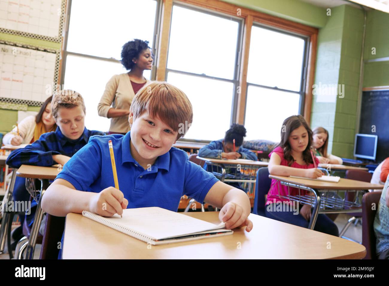 School, children and education portrait in a classroom while writing to ...