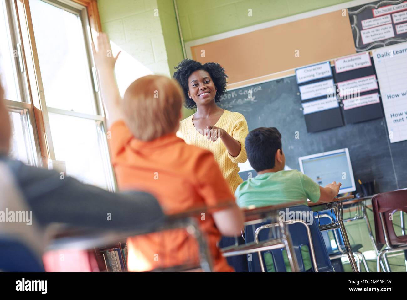 Question, education and children in classroom with teacher in academy ...