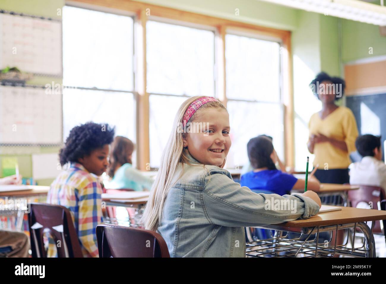 Child, school and education portrait in a classroom while writing in ...