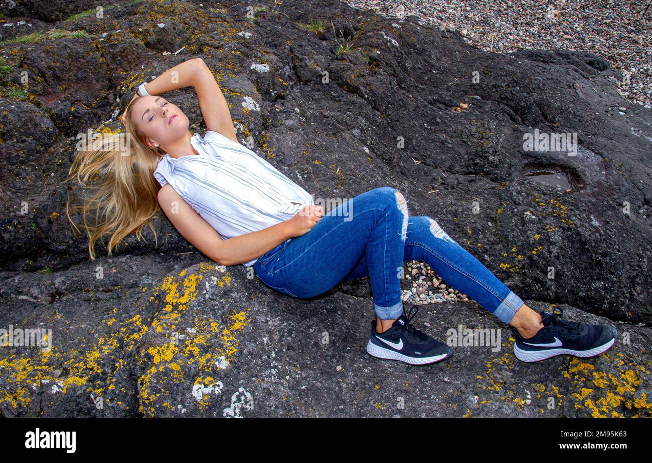 Woman sleeping on rocks hi-res stock photography and images - Alamy
