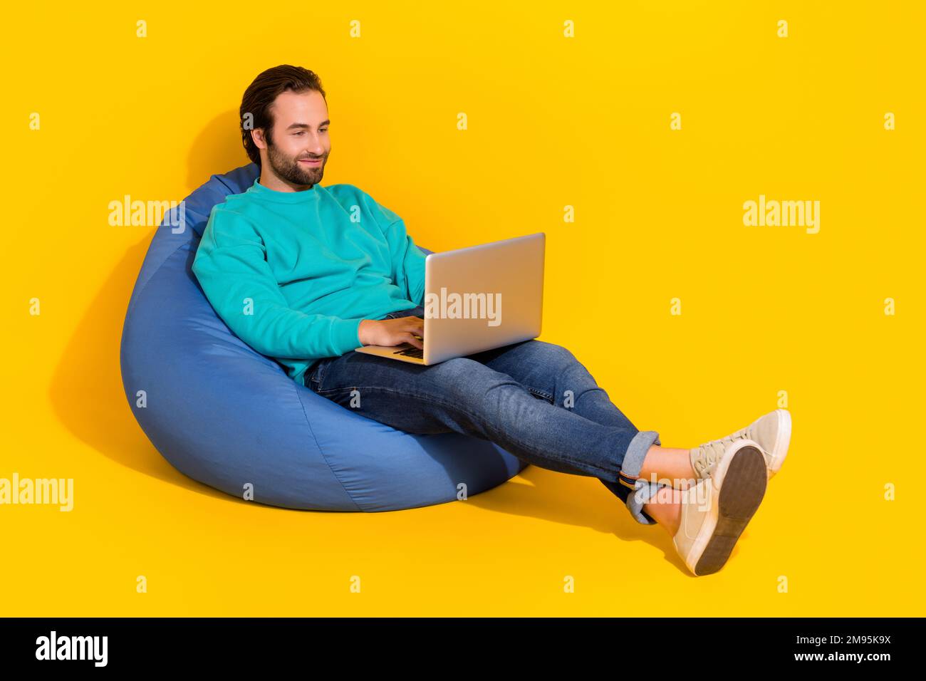 Full length photo of cheerful cool guy dressed teal outfit sitting bean ...