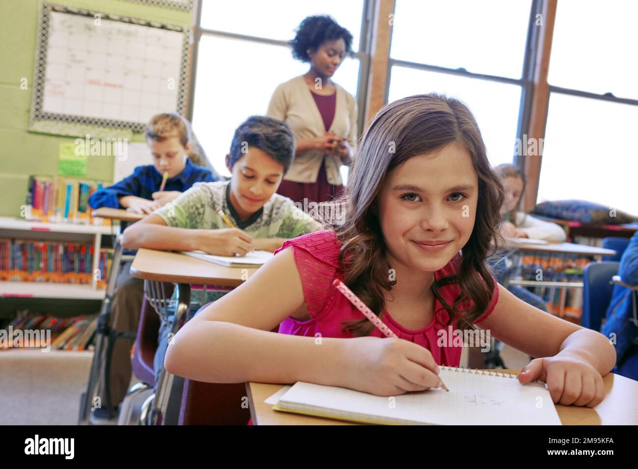 Education, girl and portrait writing in classroom with notebook for ...