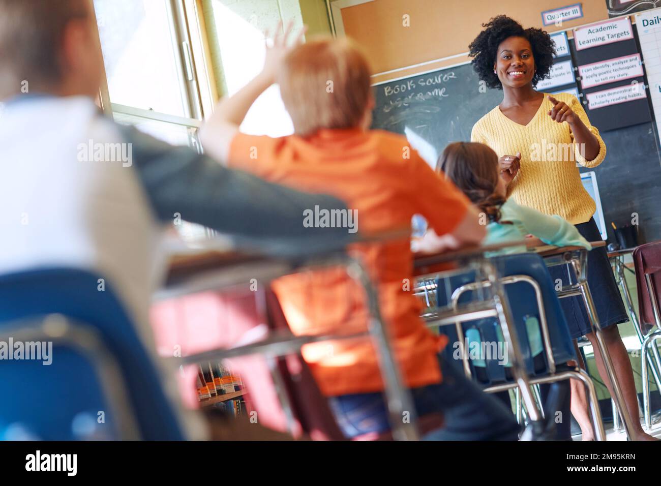 Teaching, question and children in classroom with teacher in academy ...