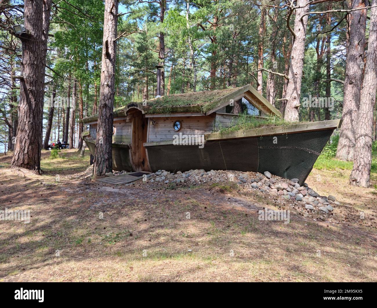 An exterior of a wooden boat-shaped hut in a green pine forest Stock ...
