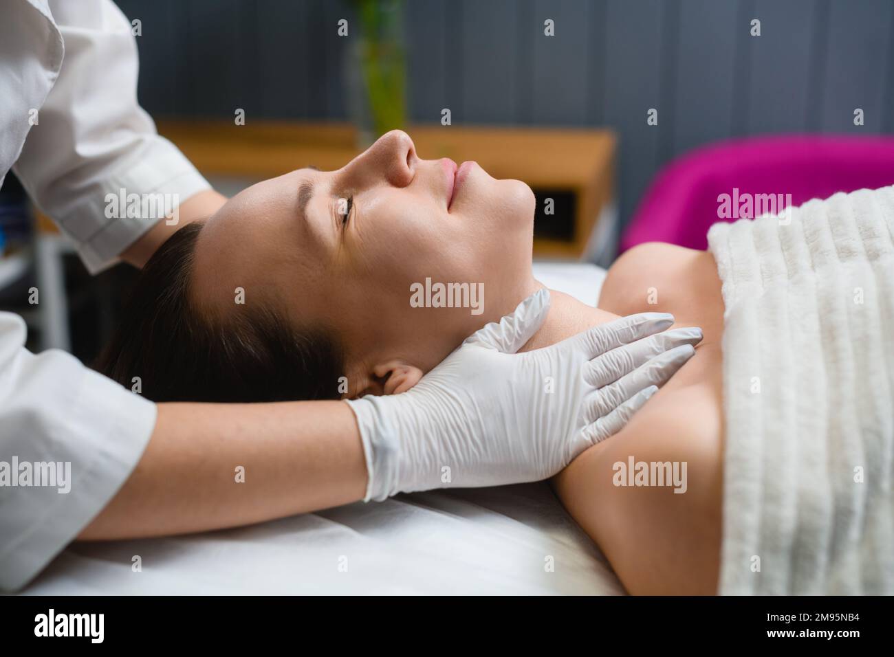 Cosmetology massage of face, neckline and shoulders in salon, masseur ...