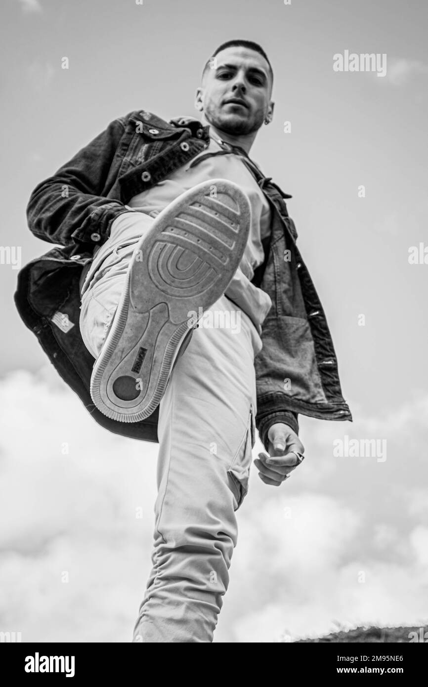A vertical grayscale closeup of a stylish young man looking at the ...