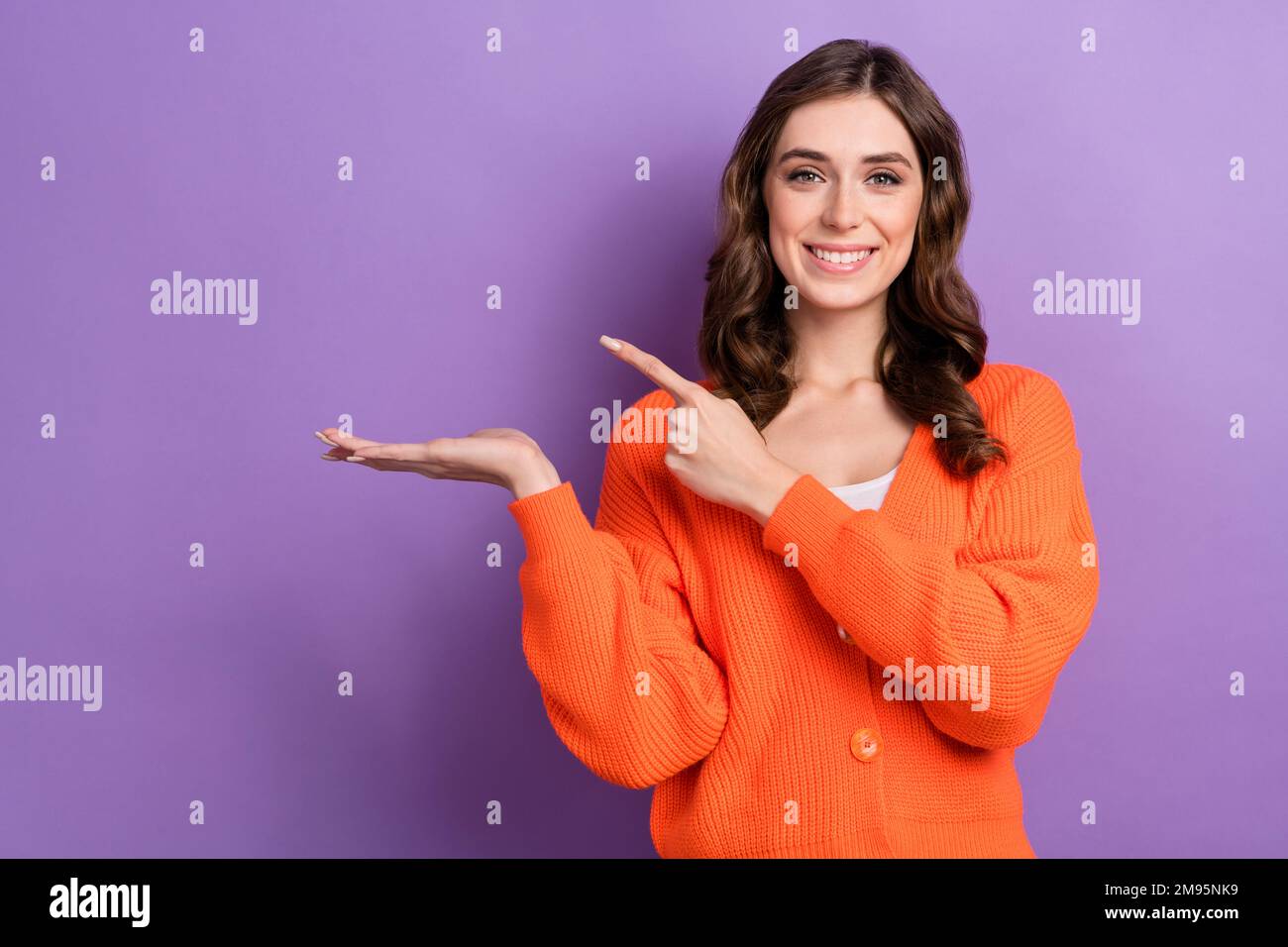 Portrait of positive nice person indicate finger arm hold empty space ...