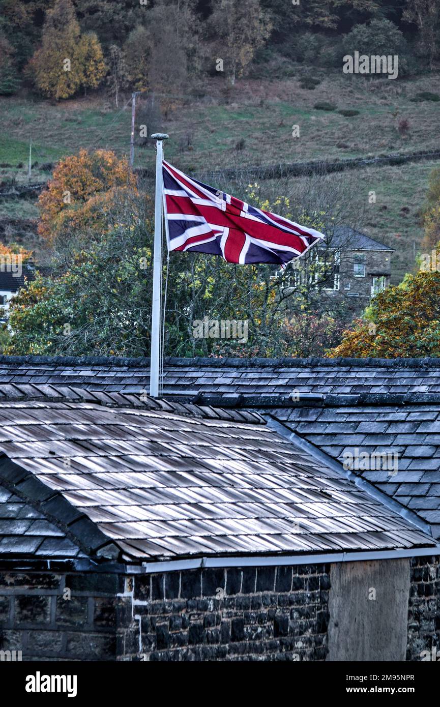 A vertical shot of the Union Jack waving in the air on the top of an ...