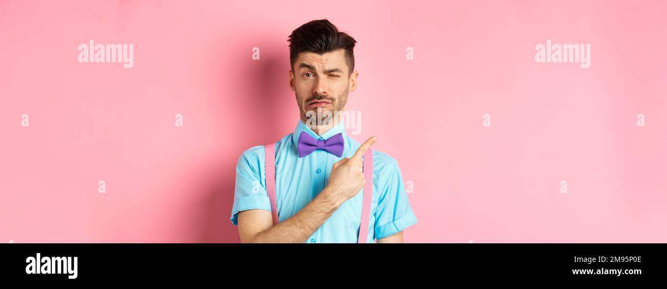 Childish young man acting sad and fake crying while pointing finger ...