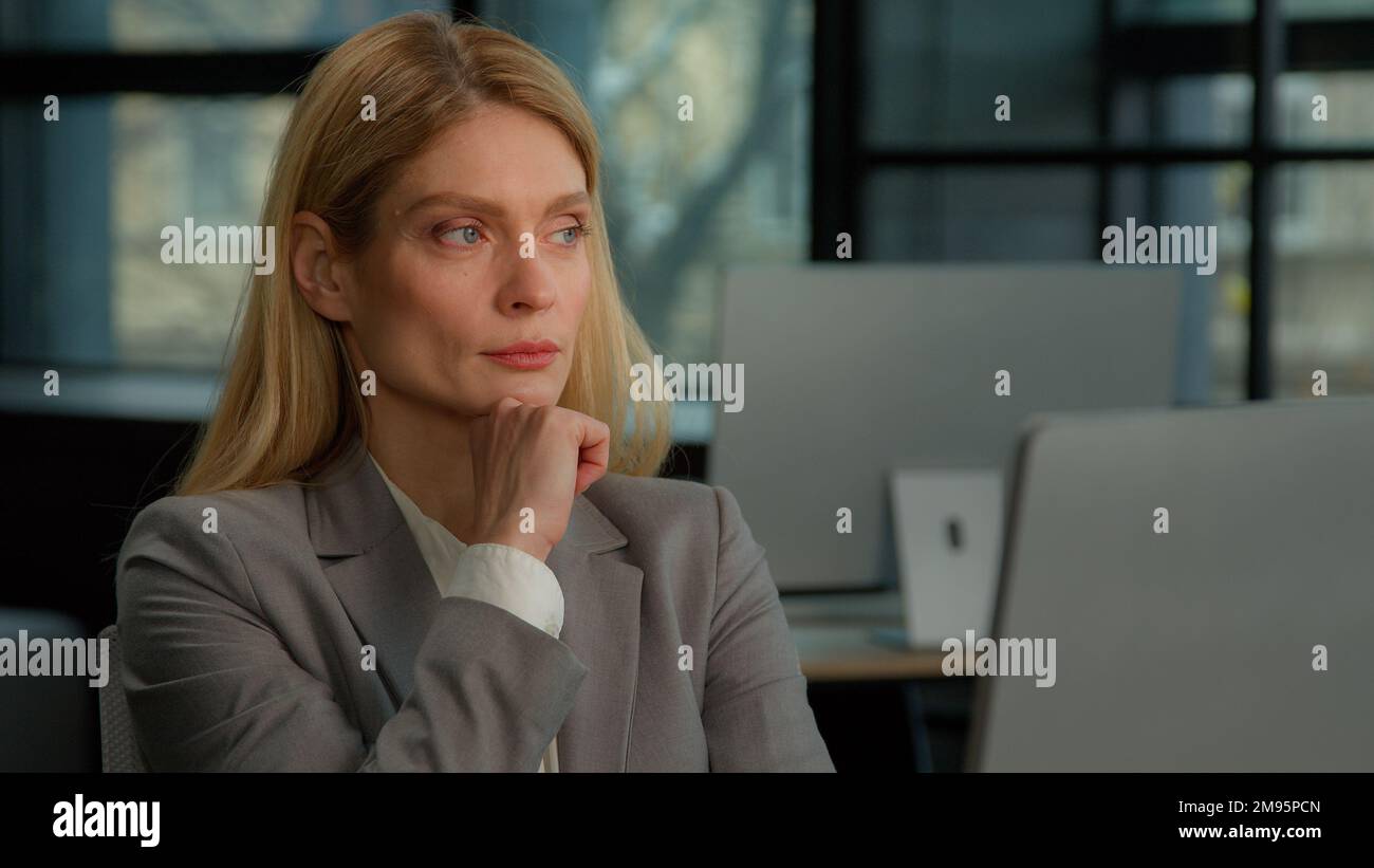 Thoughtful concerned Caucasian middle-aged adult 40s woman working on ...